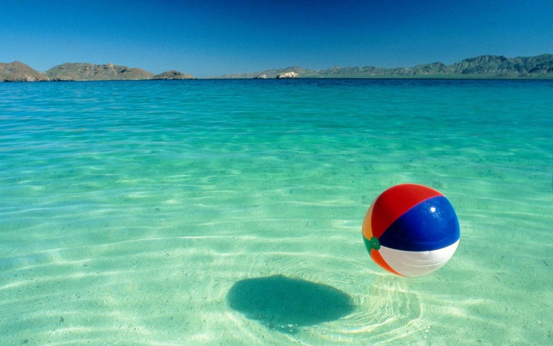 Beach ball floating on water at beach | GaleriSaham.com